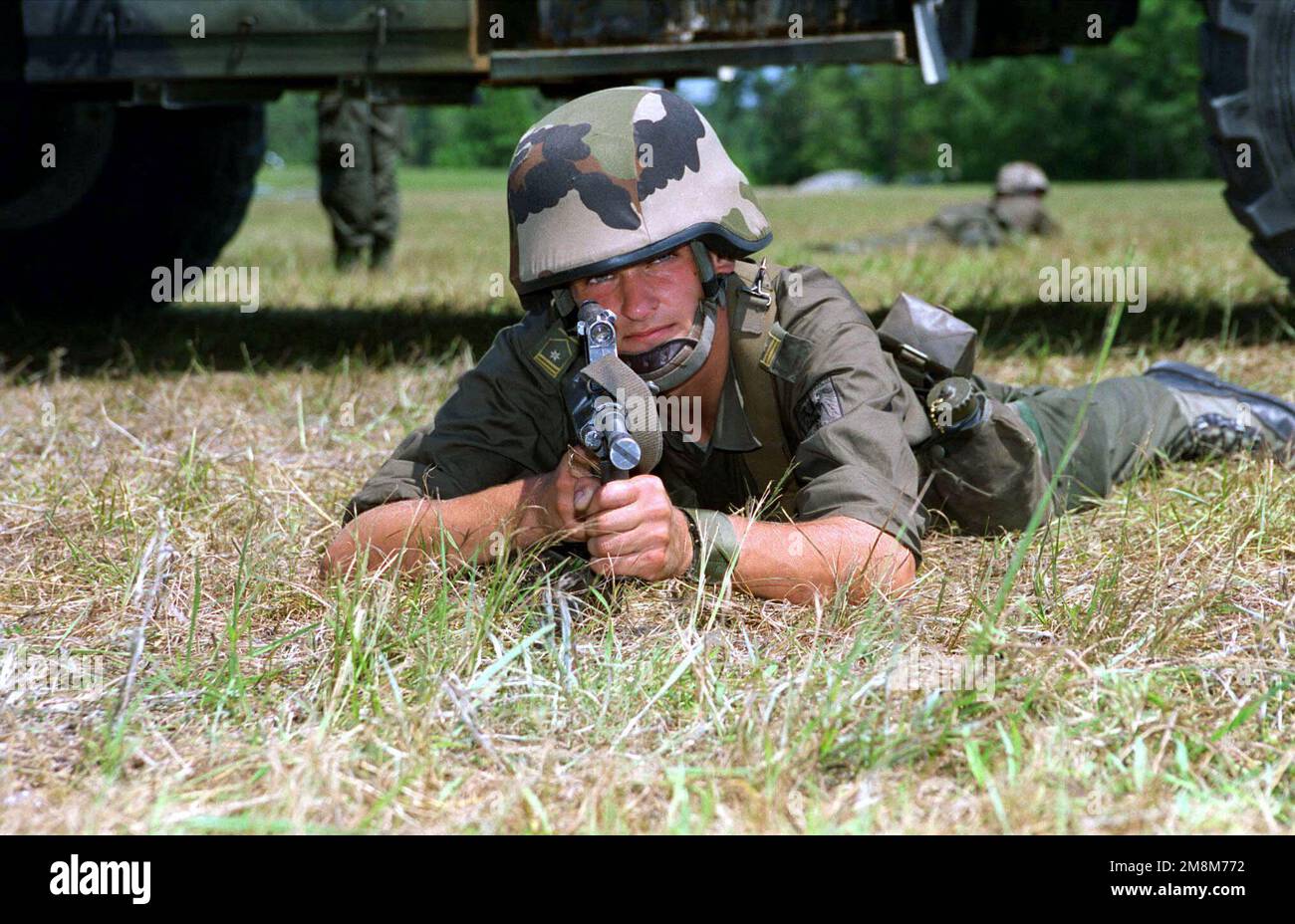 An Austrian soldier armed with a Steyr AUG rifle sits in his position ...