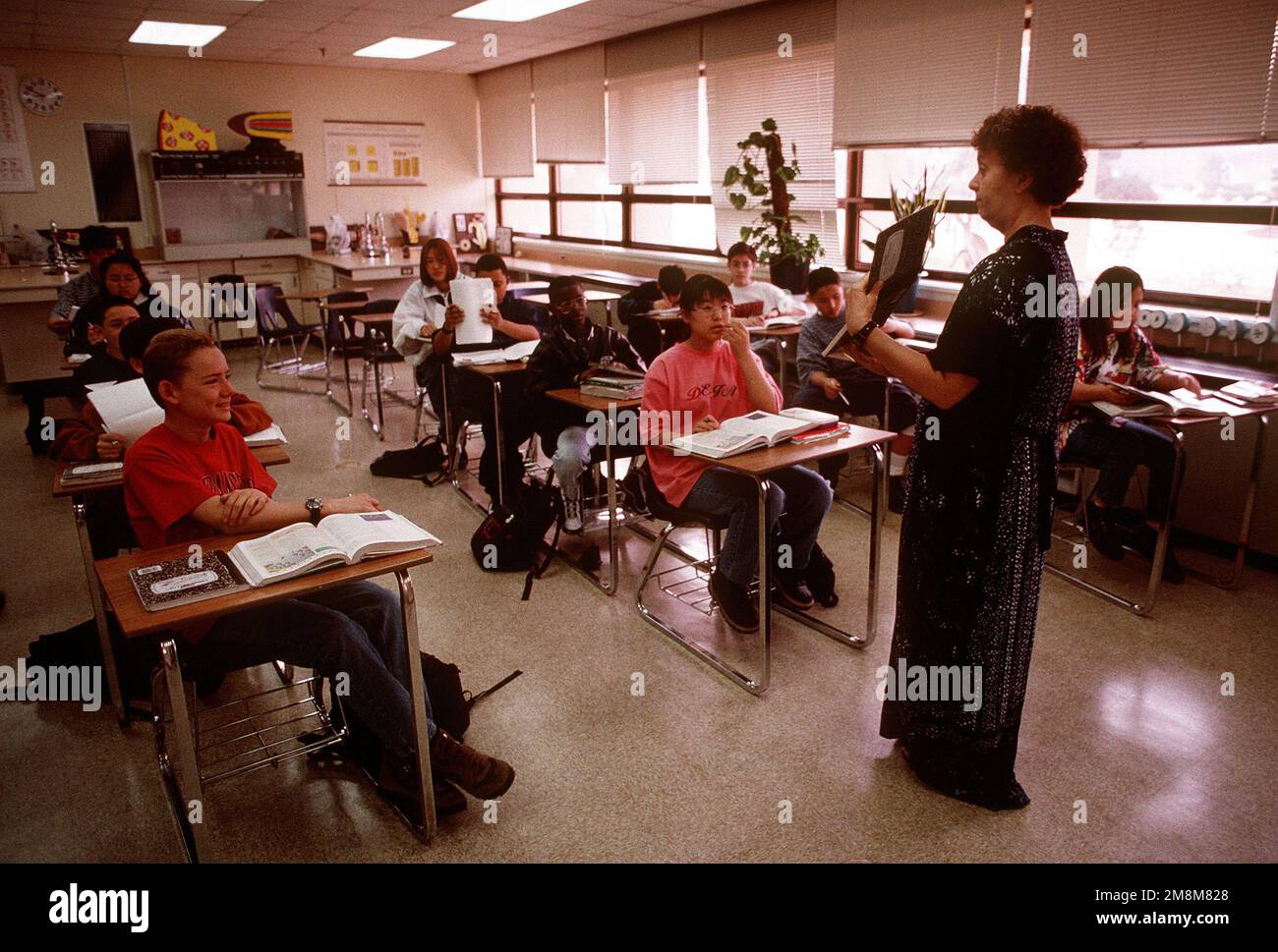 High School freshman listen as their teacher reviews an assignment. The ...