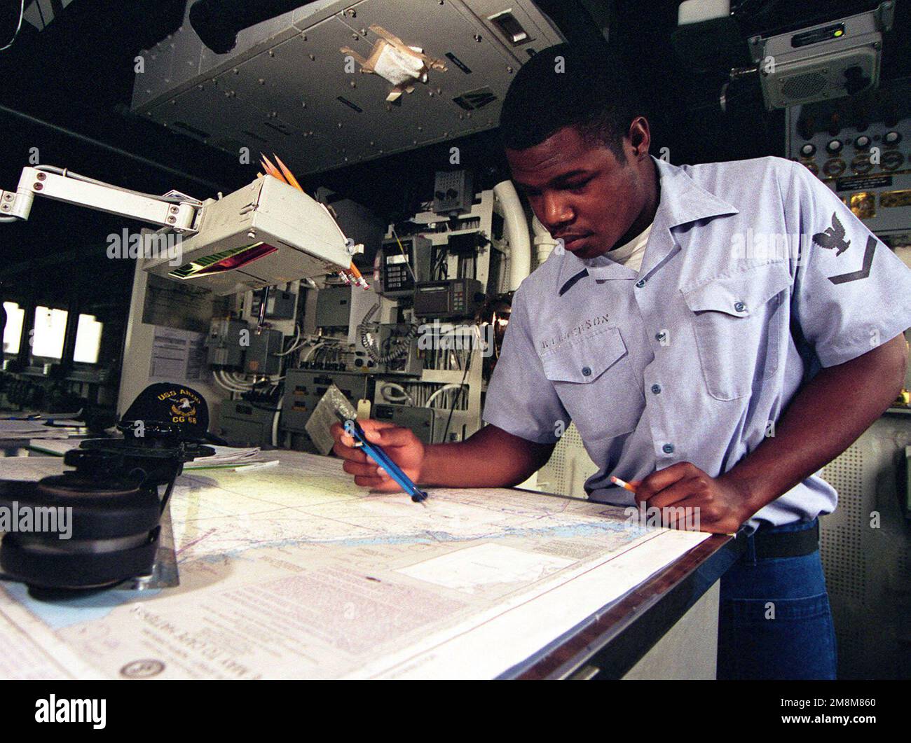 US Navy Quartermaster 3rd Class Ali J. Wilkerson plots a course on the ...