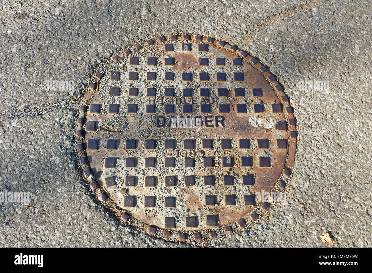 A top view of a manhole cover with the sign of danger on it Stock Photo ...