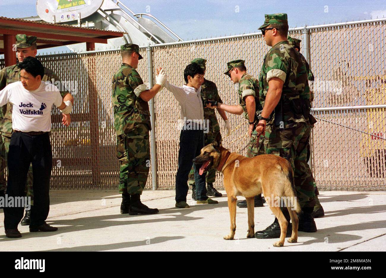 A Chinese migrant receives a clothing search for contraband as a US ...
