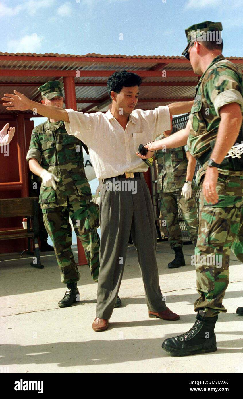 Chinese migrants are searched for contraband and weapons by US Marine ...