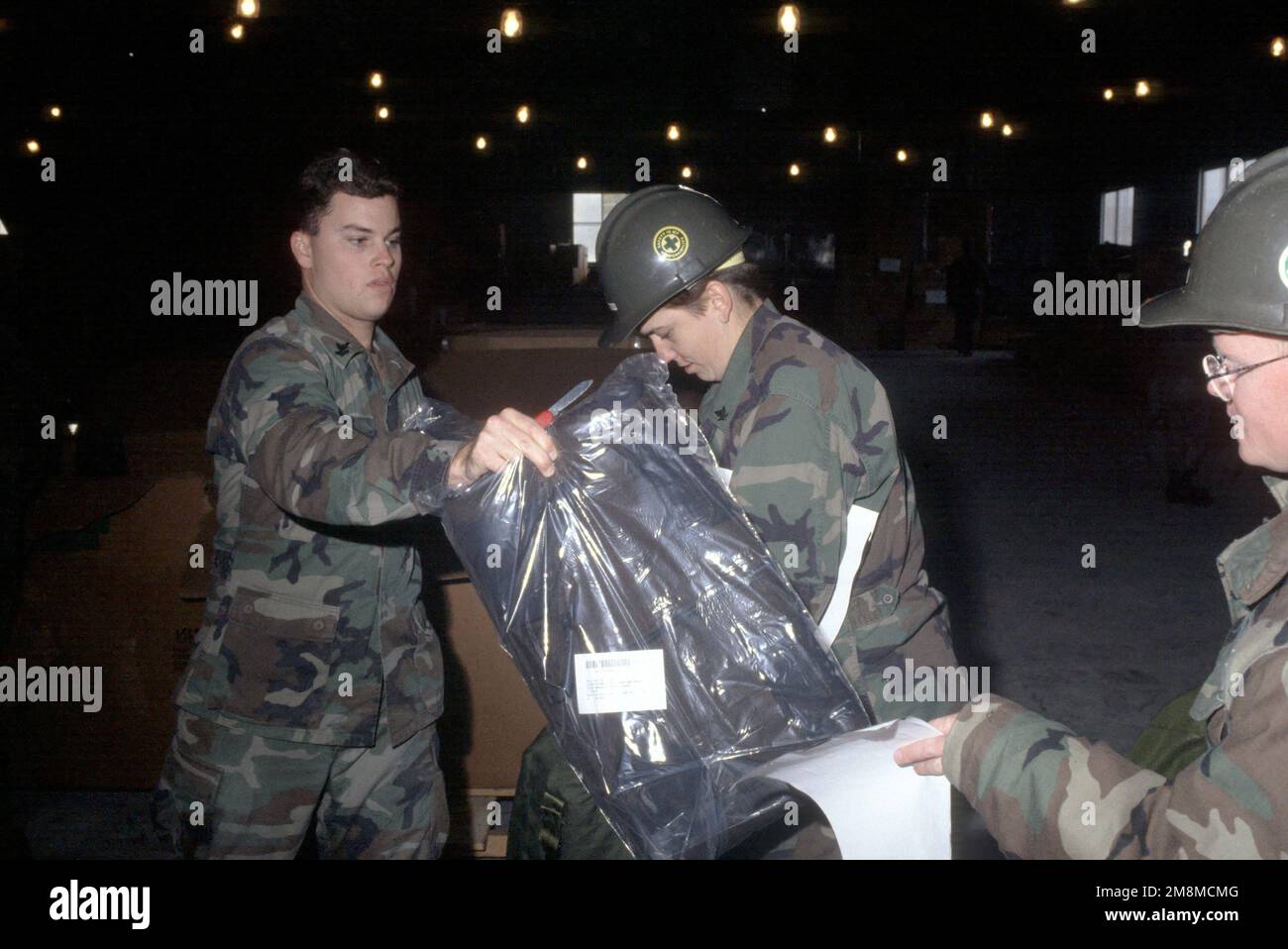 Yeoman Second Class (YN2) Clyde Lusk hands out cold weather gear to ...