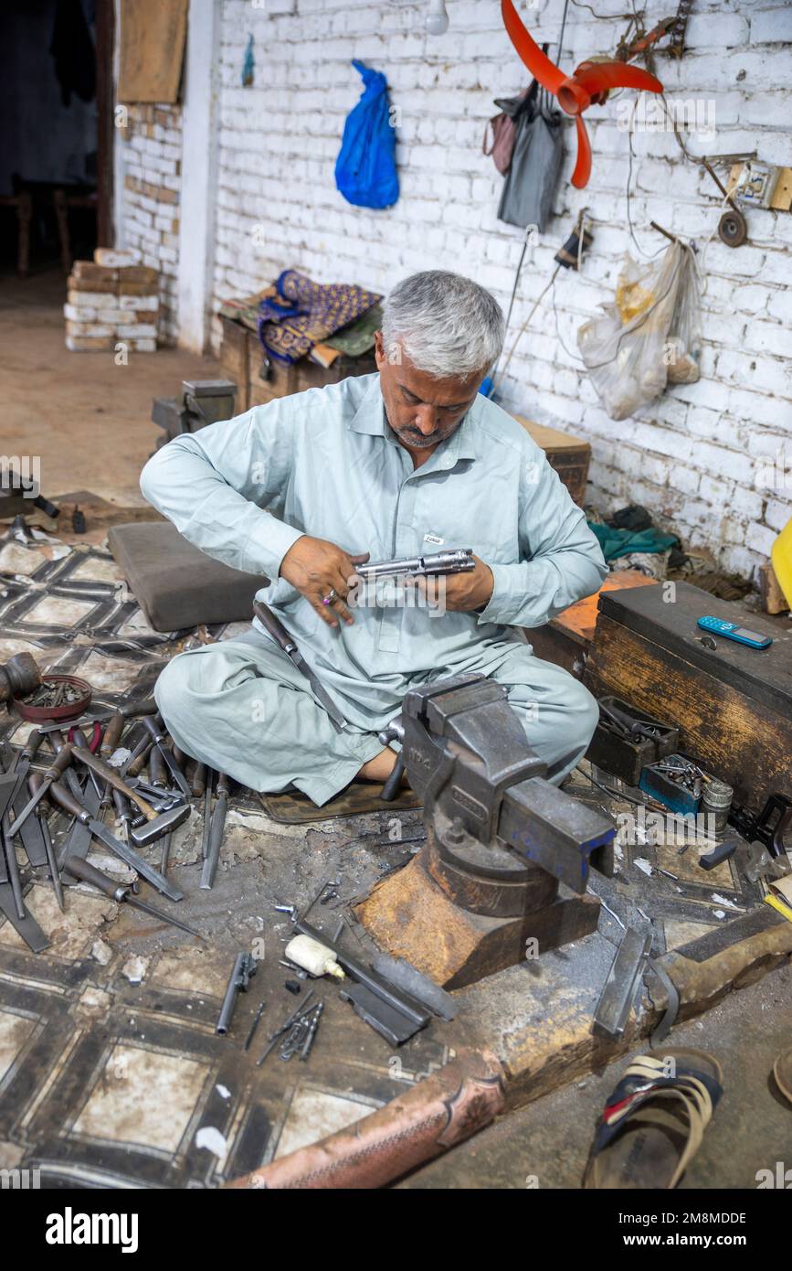 Gunsmith working on a revolver ina a weapon factory, Peshawar, Pakistan ...