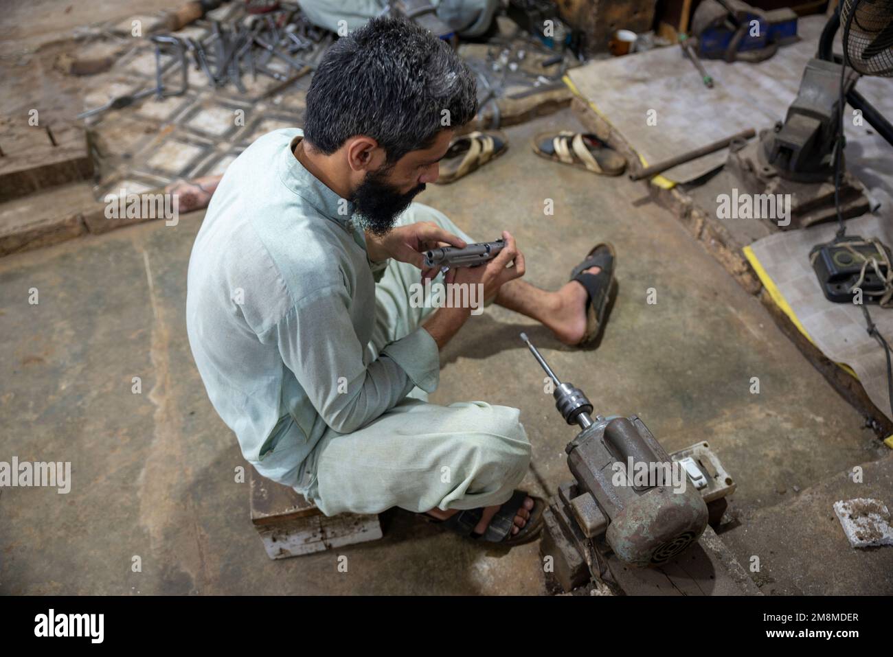 Gunsmith working on a revolver ina a weapon factory, Peshawar, Pakistan ...