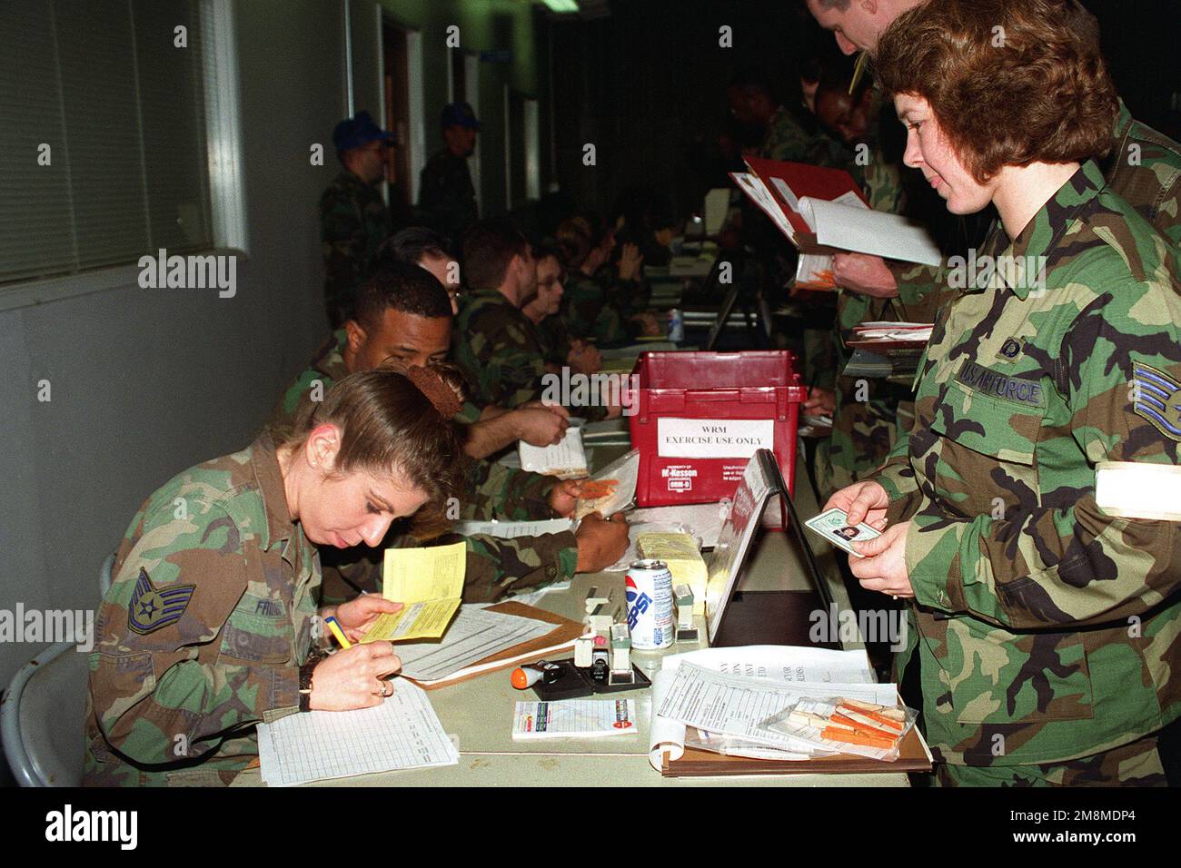 STAFF SGT. Dina Fristas checks STAFF SGT. Kelly Britton's shot records ...