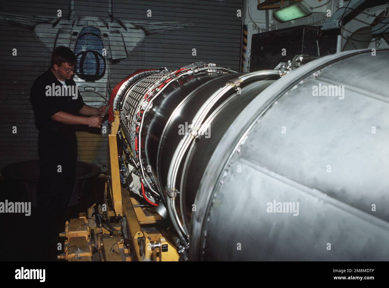 An aviation engineman works on an F-14 engine in the aircraft engine ...