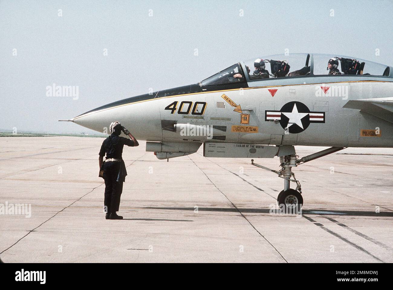 Mar 1992...A Navy plane handler gives the traditional salute to a ...