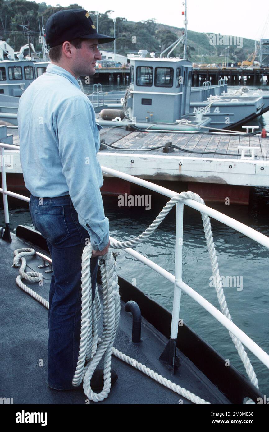 A sailor on board a tug at the Point Loma Submarine Base waits with ...