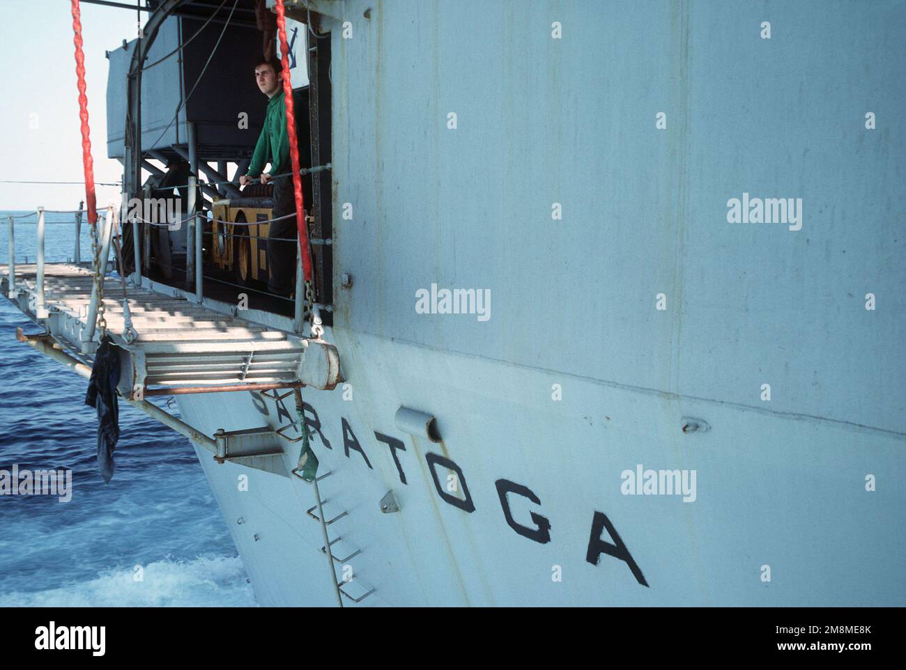 A crewman looks to sea from the fantail of the aircraft carrier USS ...