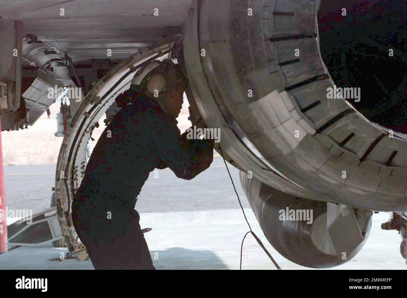 A maintenance crewmember from VF-154 performs routine checks on the jet ...