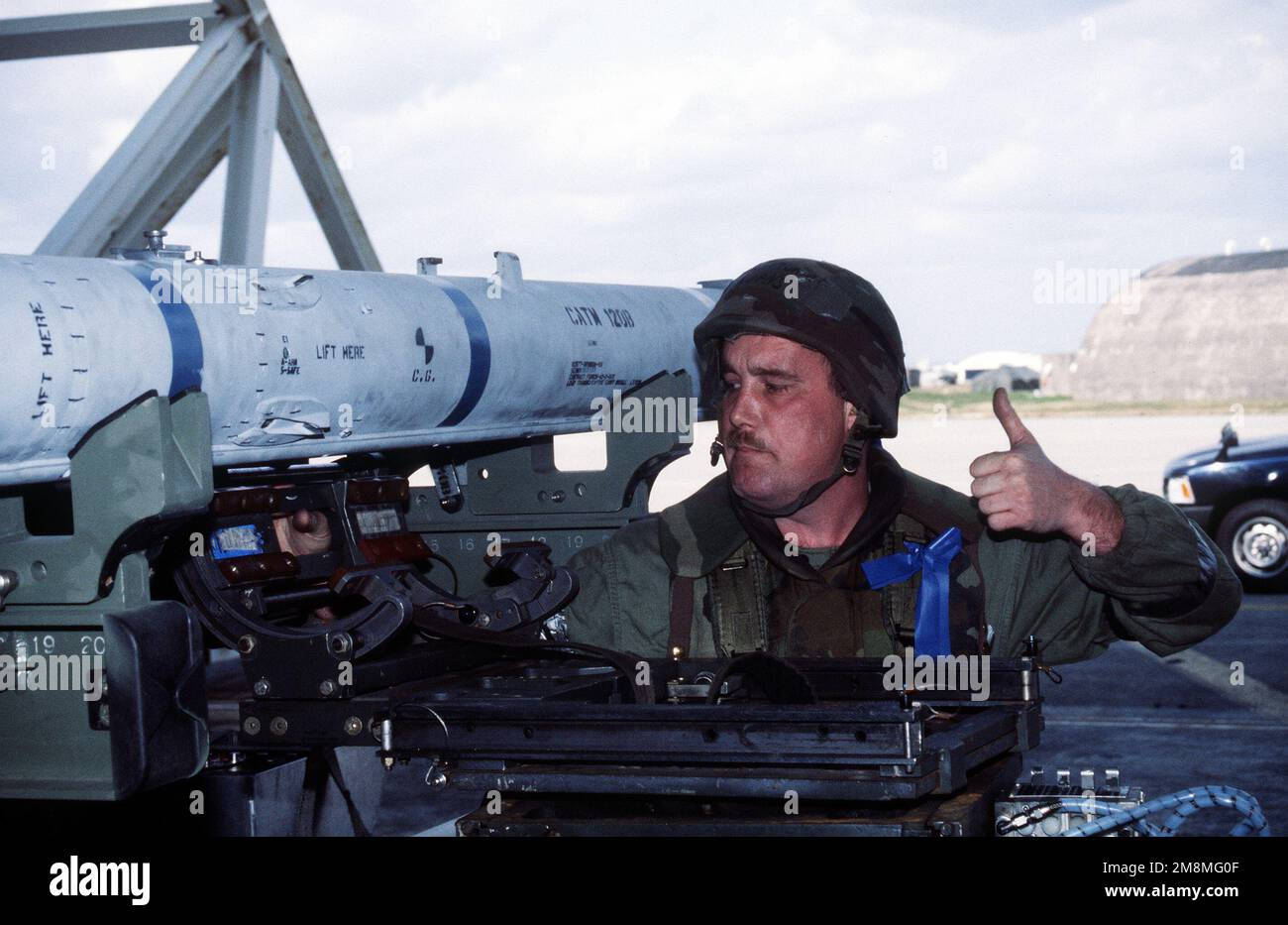 Dressed in combat gear, a munitions specialist from the 18th Munitions Squadron prepares an AIM ...