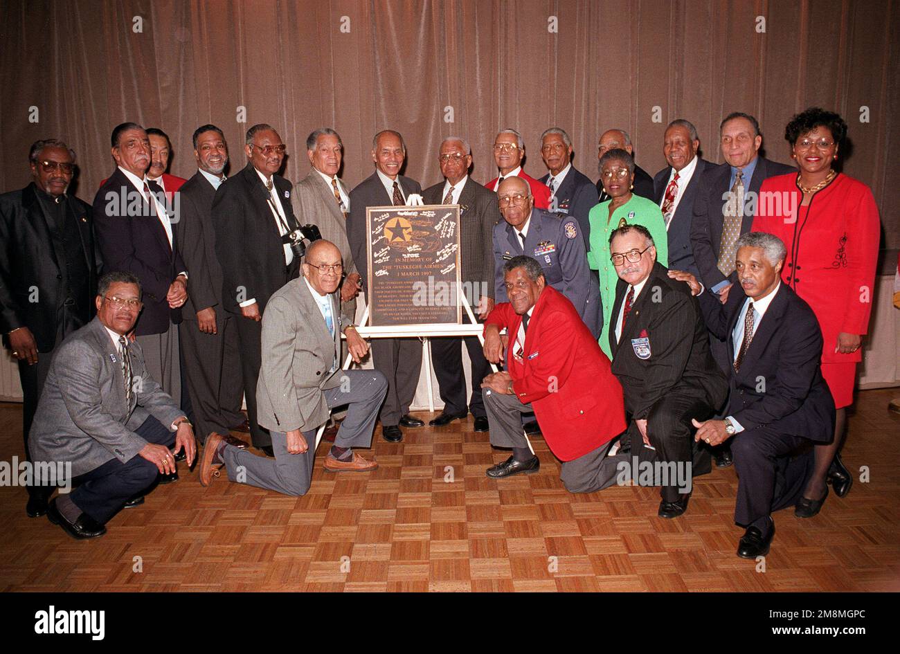 Members of the Tuskegee Airmen gather around a signed photographic copy ...