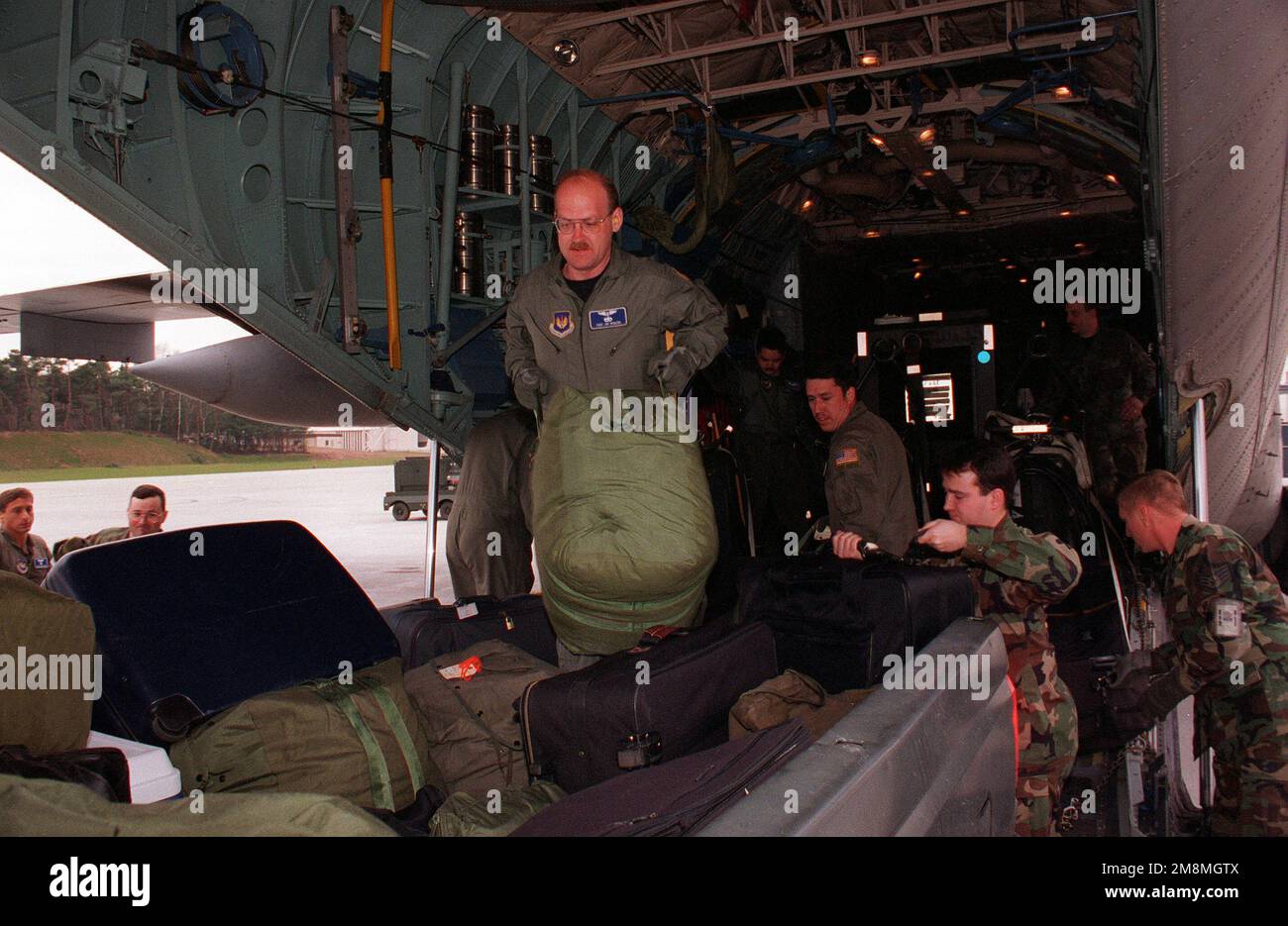 Members of the 37th Airlift Squadron down load their luggage from a C ...