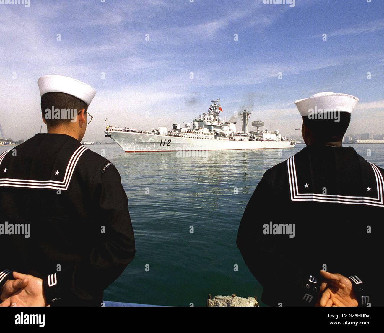 Framed between two U.S. Navy Sailors, the guided missile destroyer ...