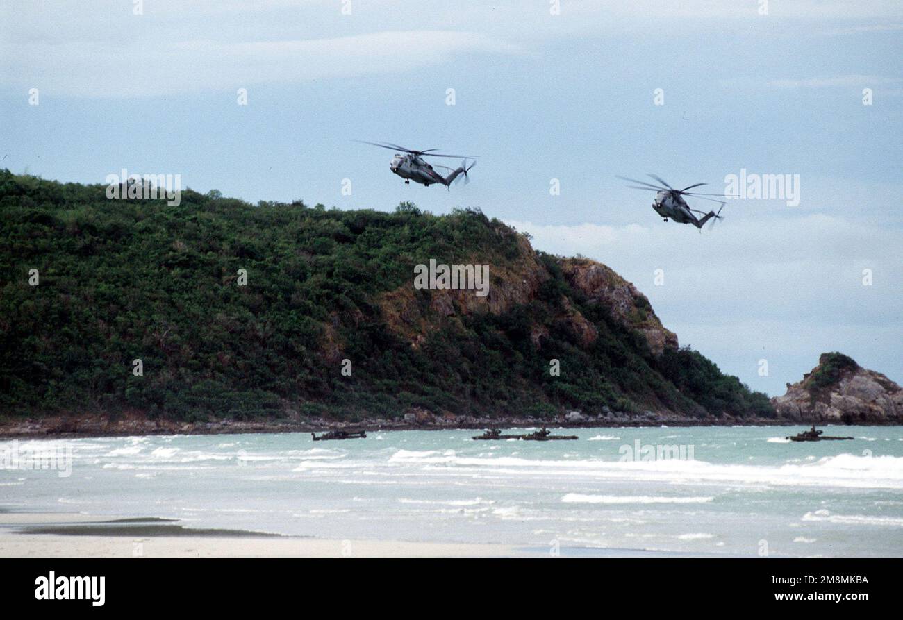 Two US Marine Corps CH-53's fly overhead as amphibious assault vehicles ...