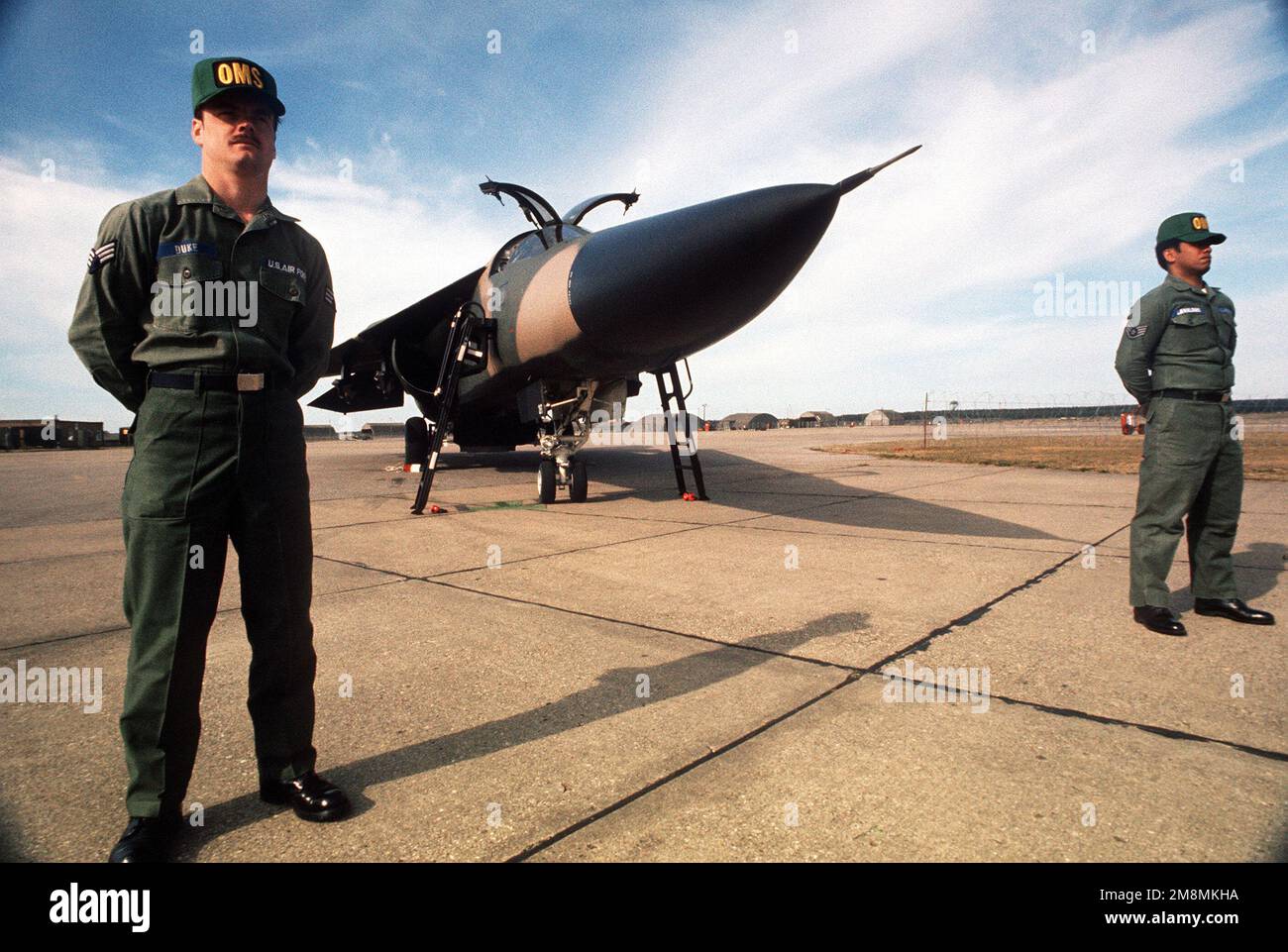 Crew chiefs of two F-111F aircraft stand at attention in front of their ...