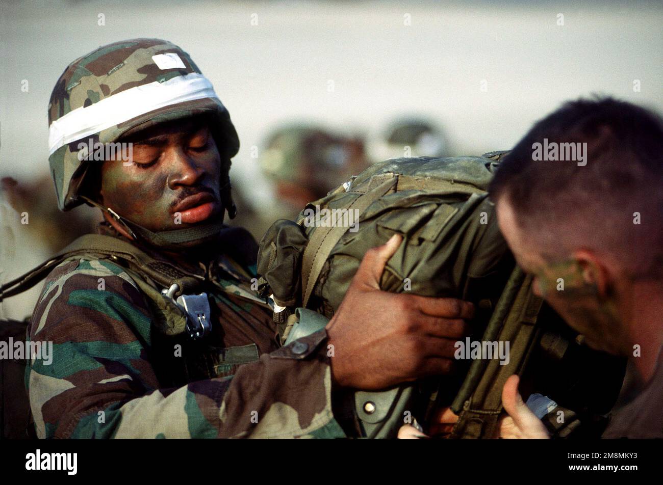 A US Army soldier lifts his emergency (chest) parachute pack for ...