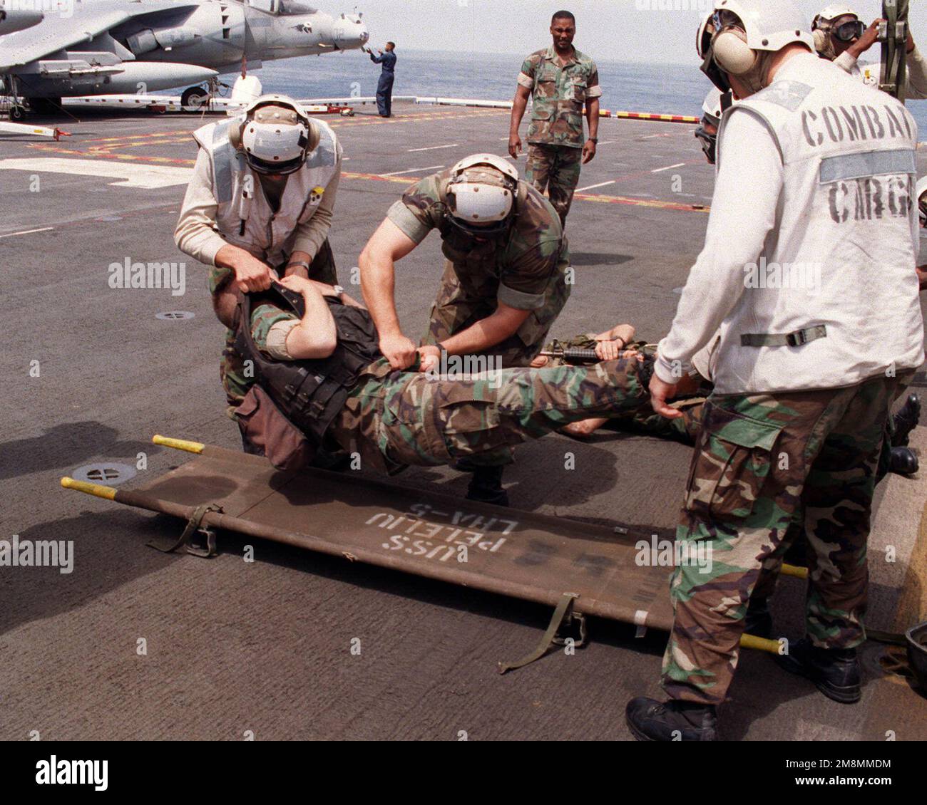 US Marines on board the USS PELELIU (LHA-5) Combat Cargo Department lower a wounded man onto a ...