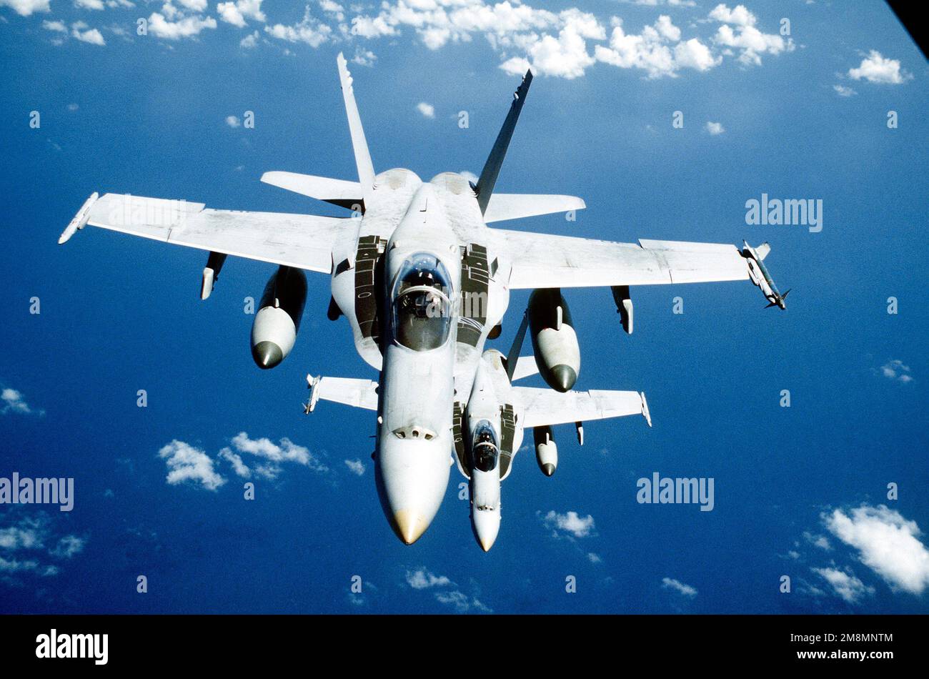 Two Navy F-18 Hornet aircraft, serving as aggressors, fly together ...