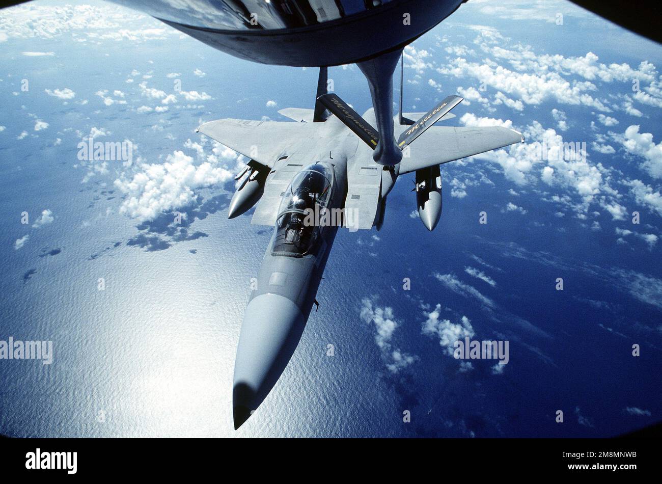 An overhead close-up view of an F-15 under the refueling boom of a KC ...
