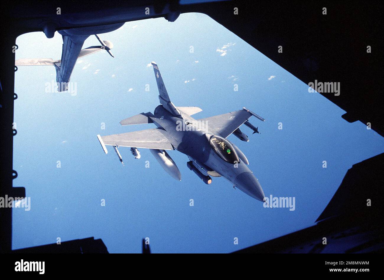 An F-16 Falcon can be seen through the boom operator's window of a KC ...