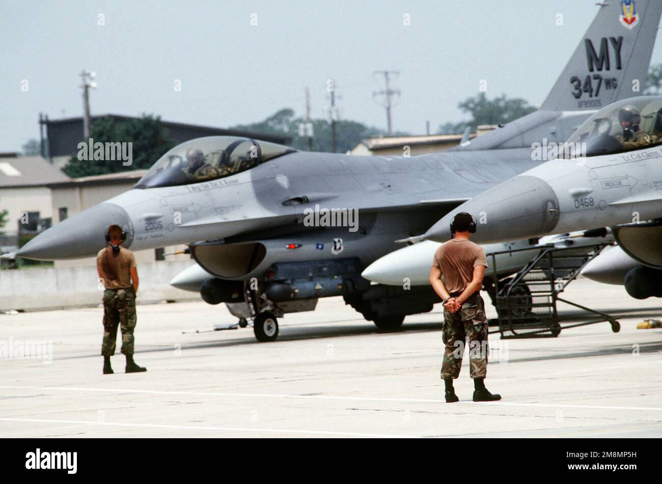 Two F-16 Falcon aircraft wait for taxi instructions before a bombing ...