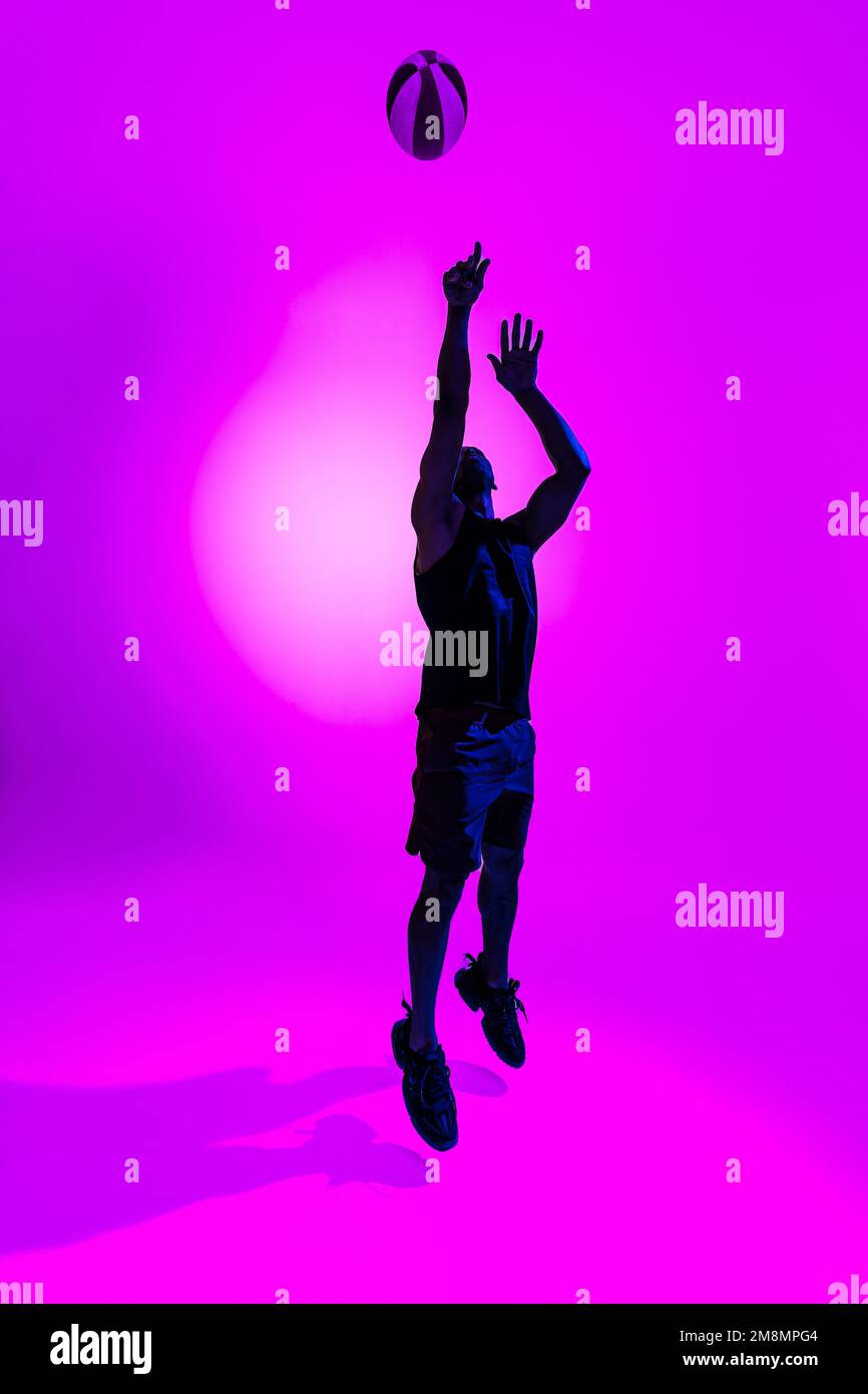 Basketball player throws the ball on studio background. Advertising ...