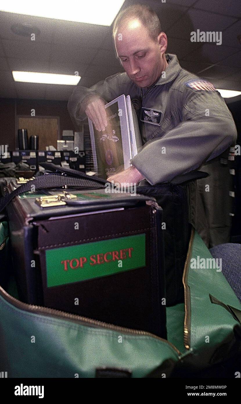 Air Force MSGT Lee W. Arnold packs top secret documents to take on an E ...
