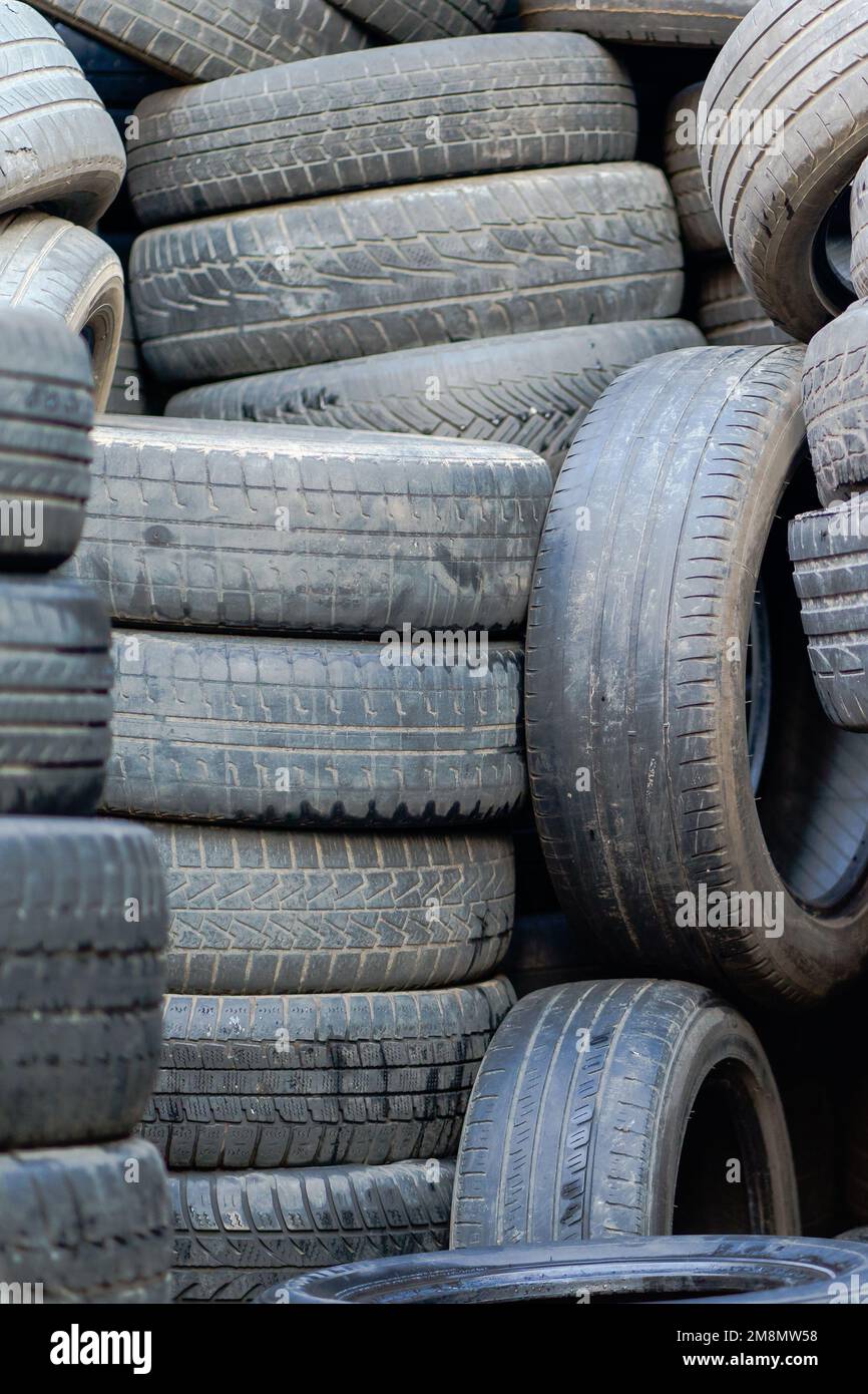 Old used rubber tires stacked with high piles. Hazardous waste ...