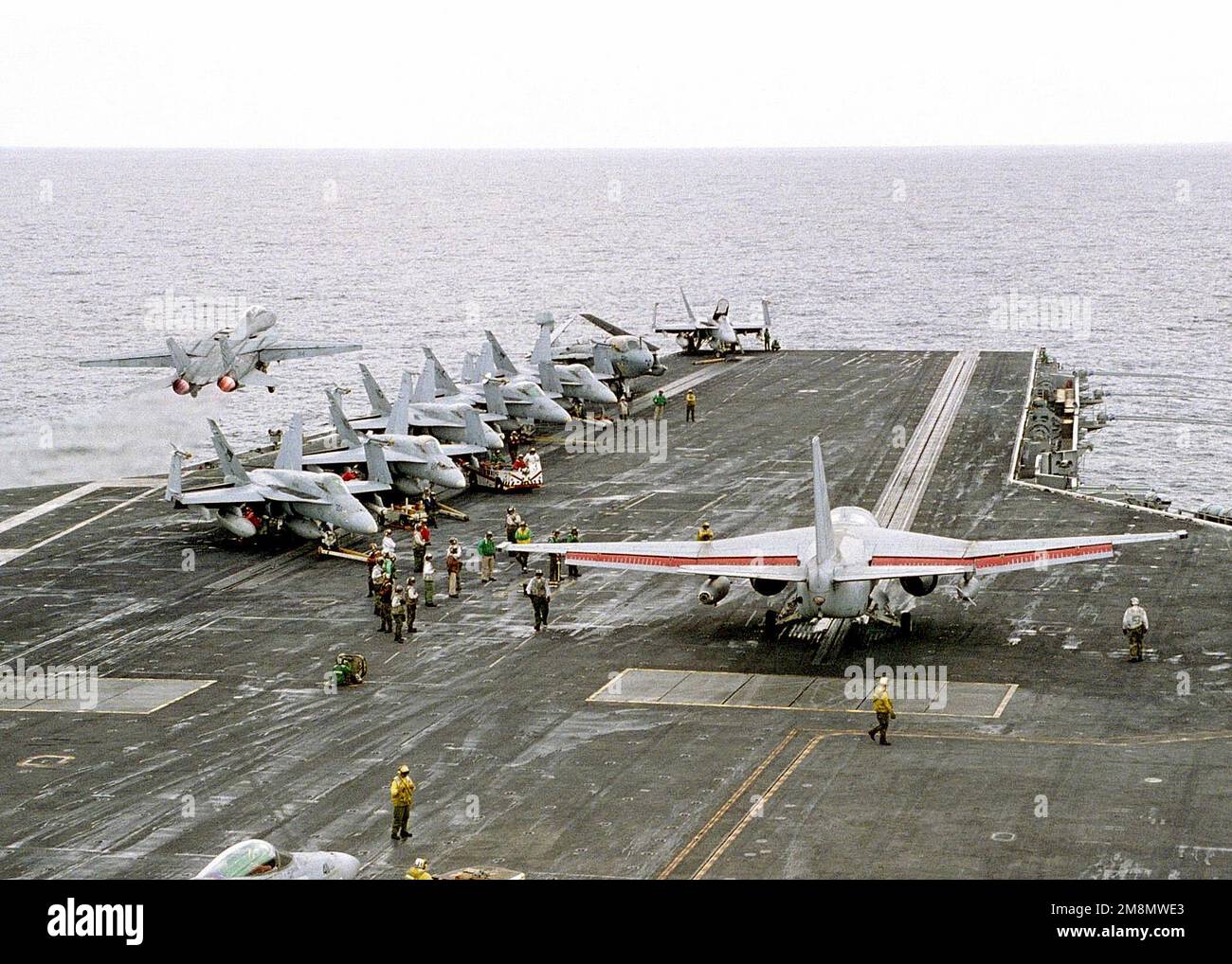 A US Navy F-14 Tomcat (left) assigned to Fighter Squadron Two One One ...