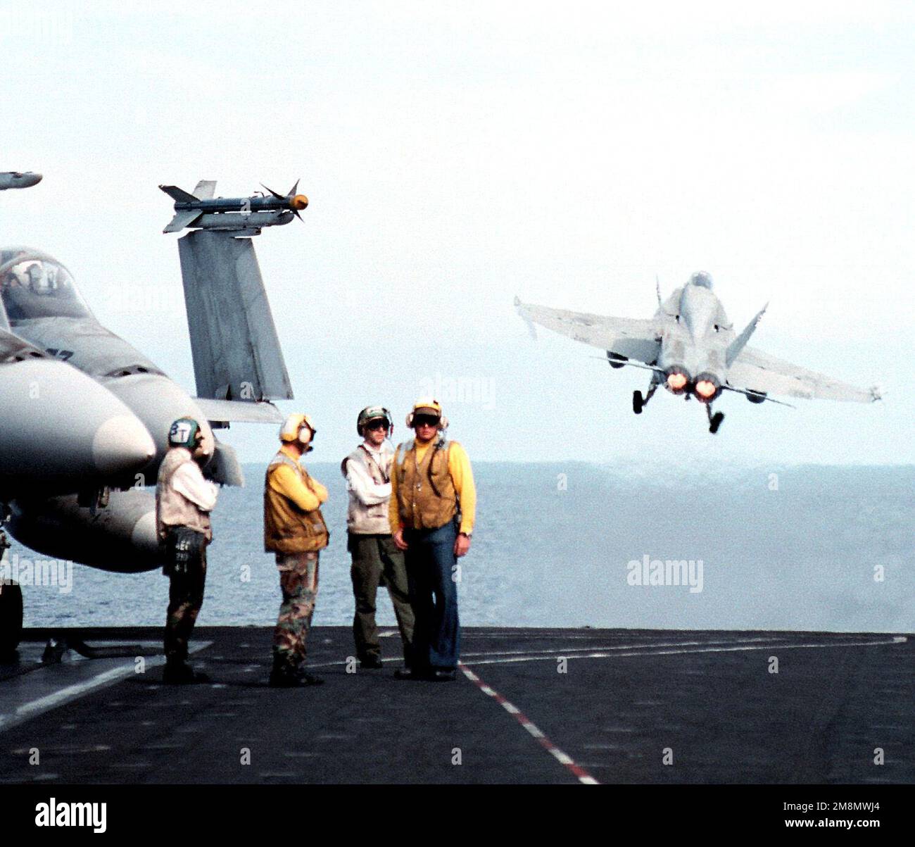 Flight deck crew observe flight deck safety as an F/A-18C Hornet from ...
