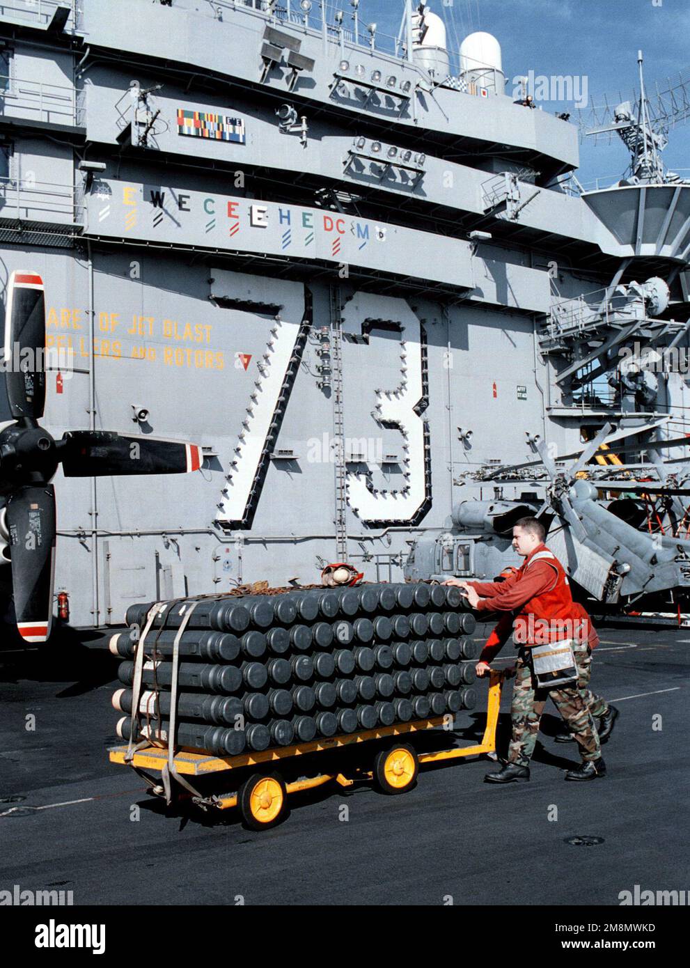 Aviation Ordnanceman, AIRMAN Luke Goodine pushes a cart of sonobouys ...