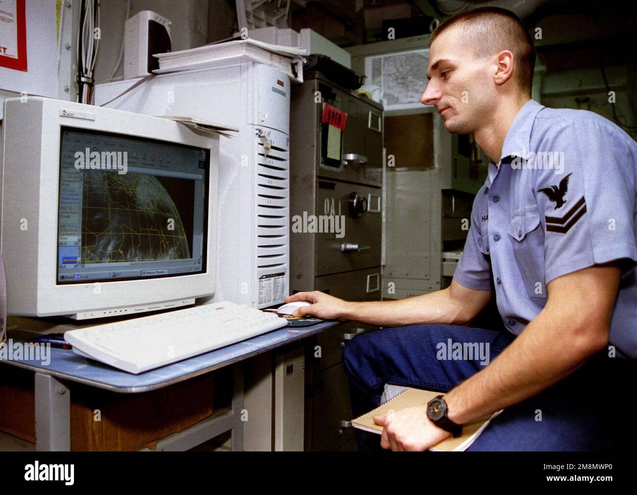 Aerographers Mate 2nd Class Mike Harris analyzes satellite weather ...