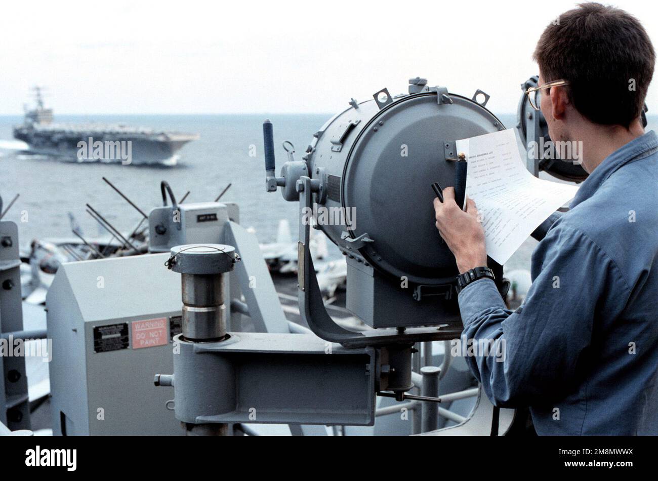 Signalman Second Class PETTY Officer James Kennedy flashes Morse code ...
