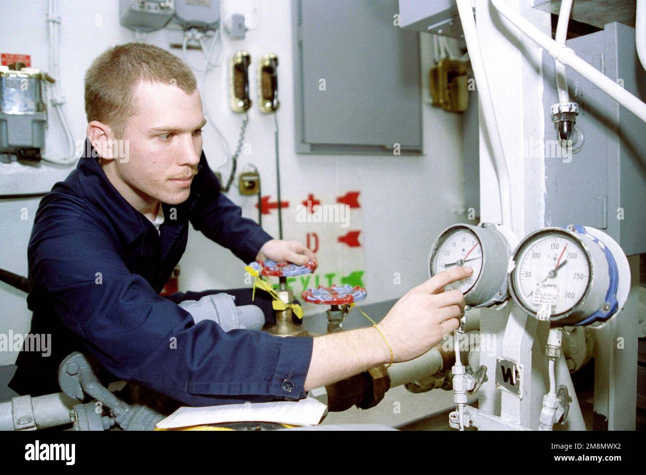 US Navy AIRMAN Apprentice (AA) Robert Ging monitors the pressure gauge ...