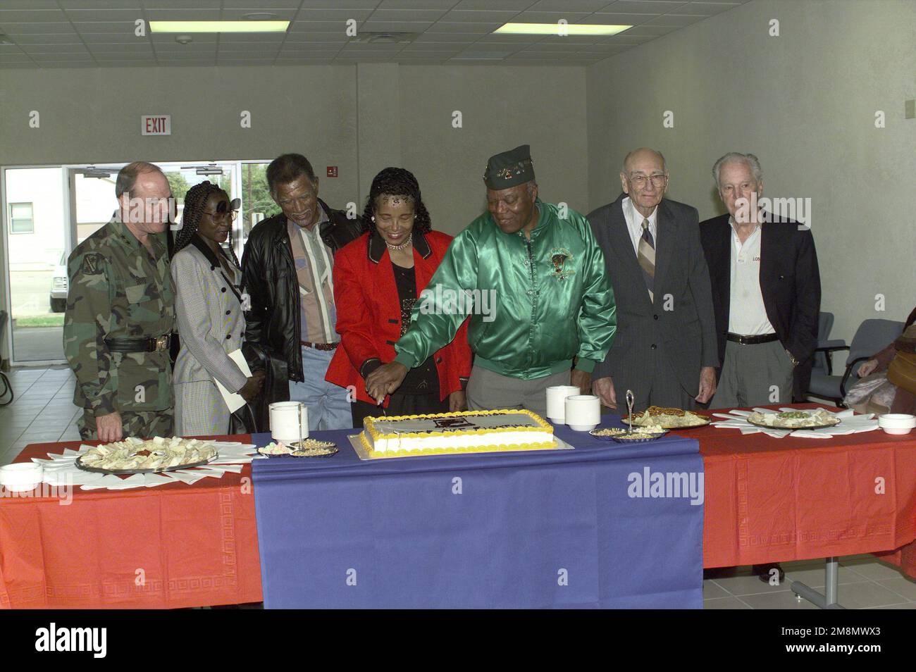 Mrs. Rivers and guests cut the cake at the rededication ceremony of ...