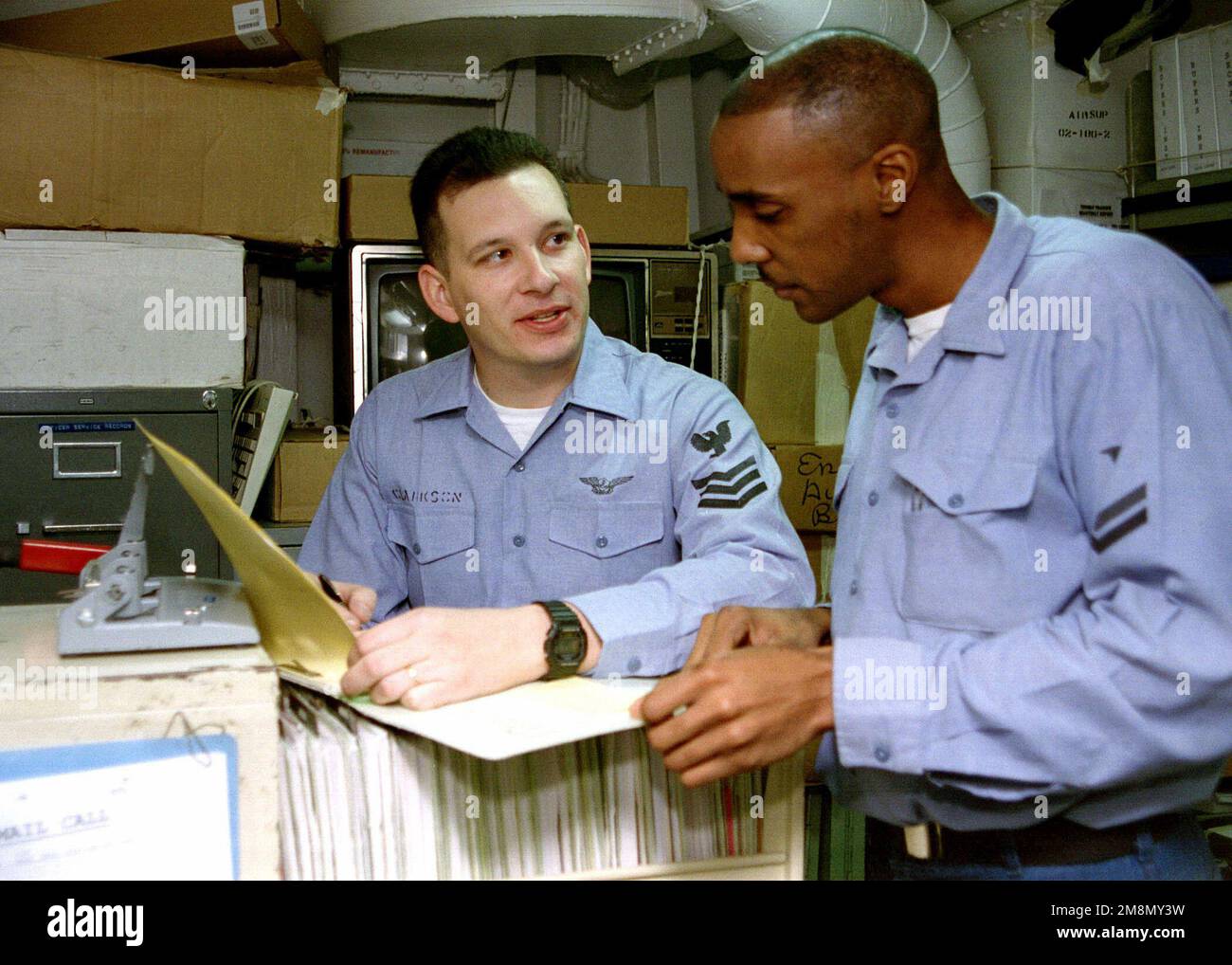 US Navy Personnelman 1ST Class (PN1) Jon D. Clarkson (left) instructs ...