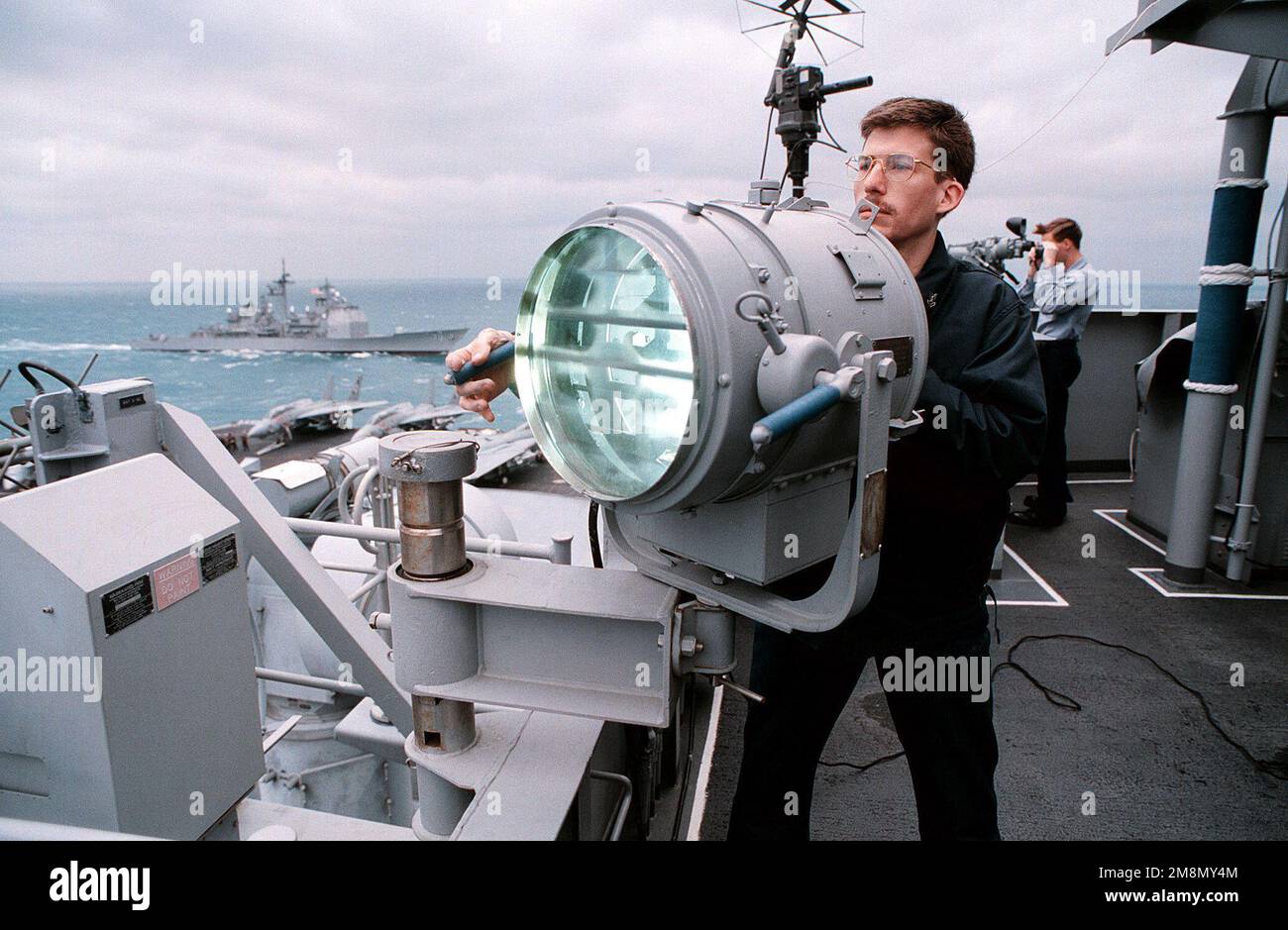 Signalman Second Class James Kennedy sends signals to ships in the ...