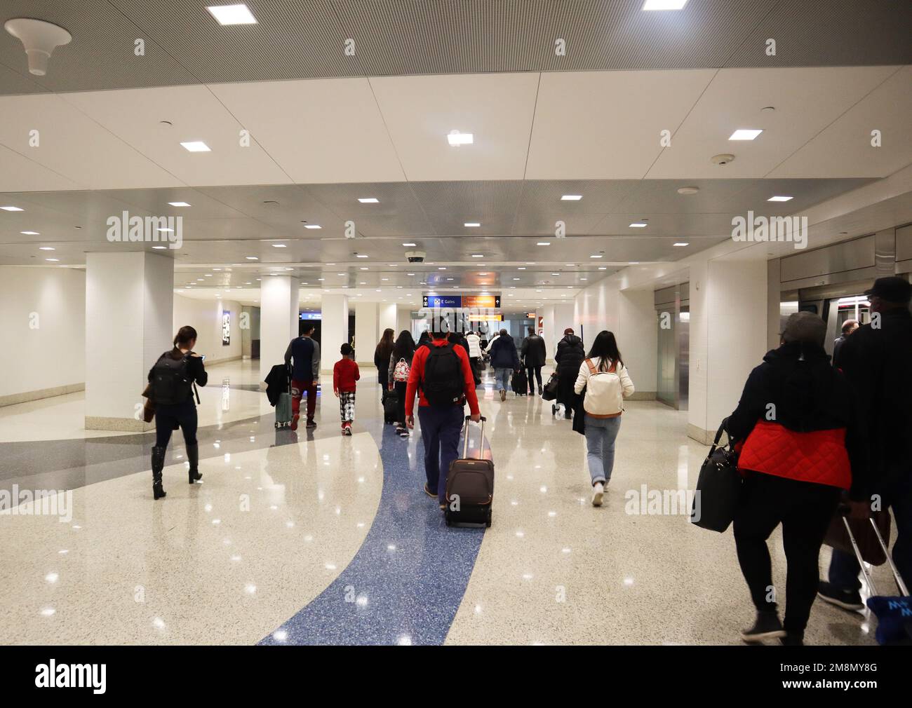 Passengers walking at airport corridor with luggage Stock Photo - Alamy