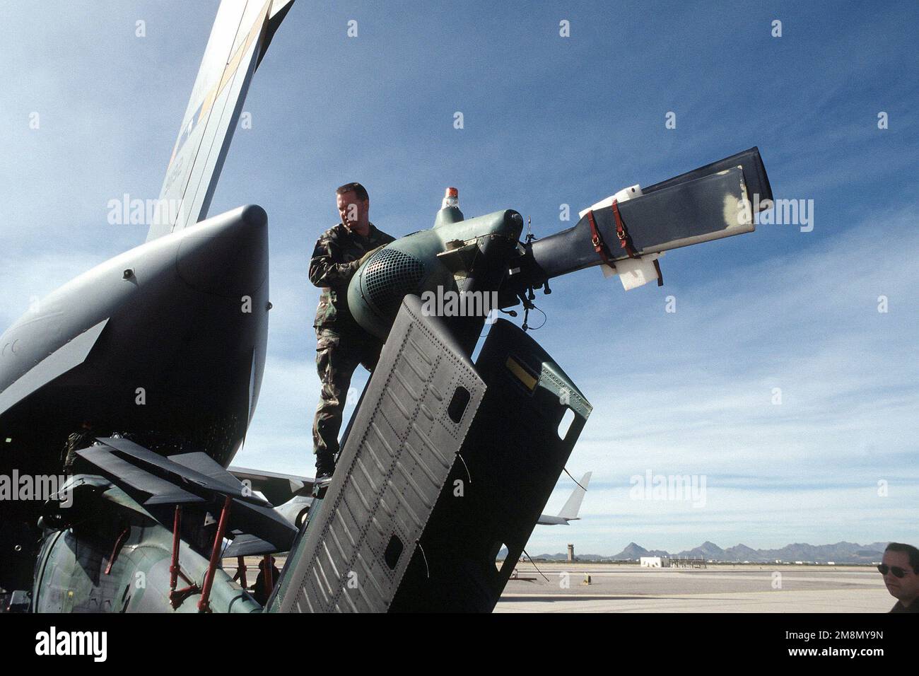 Technical Sergeant Scott Martin checks the security of the tail rotor ...