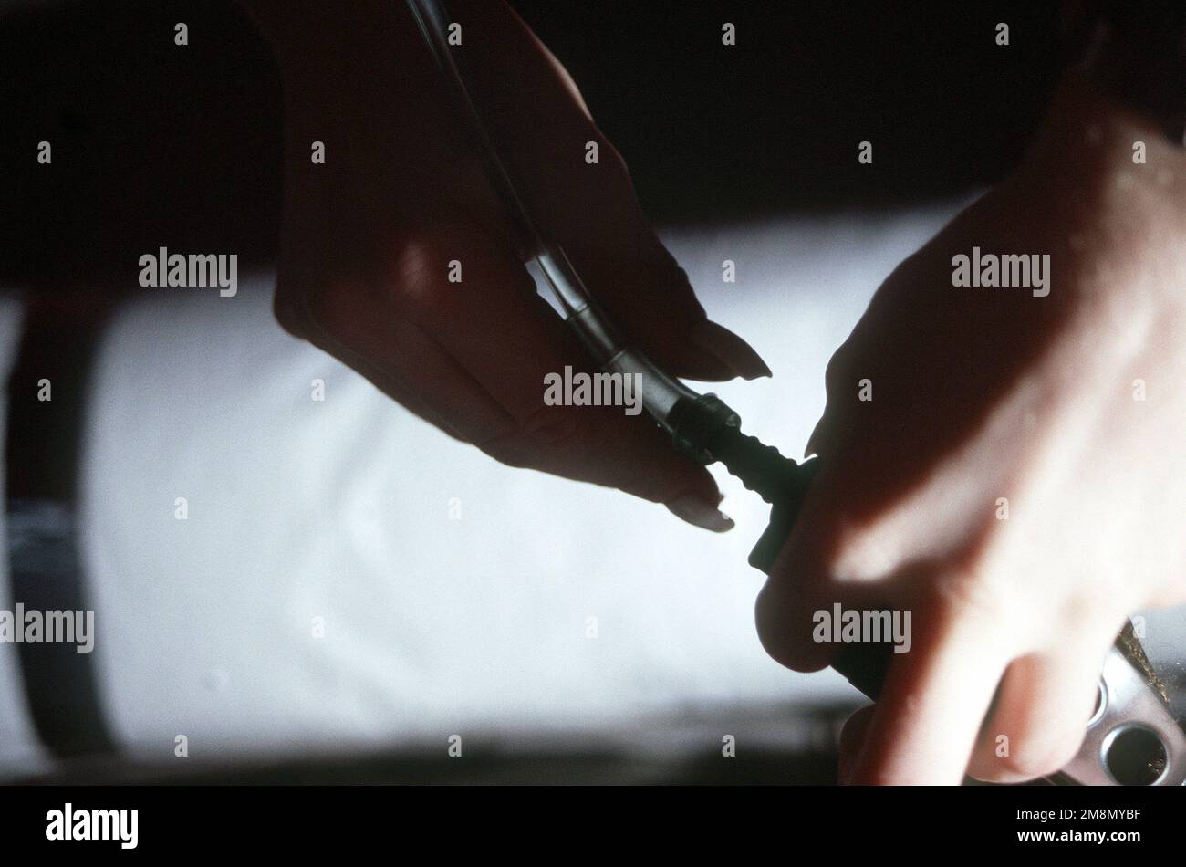 Hands at work, trying to install an IV pump. Members of the 452nd ...