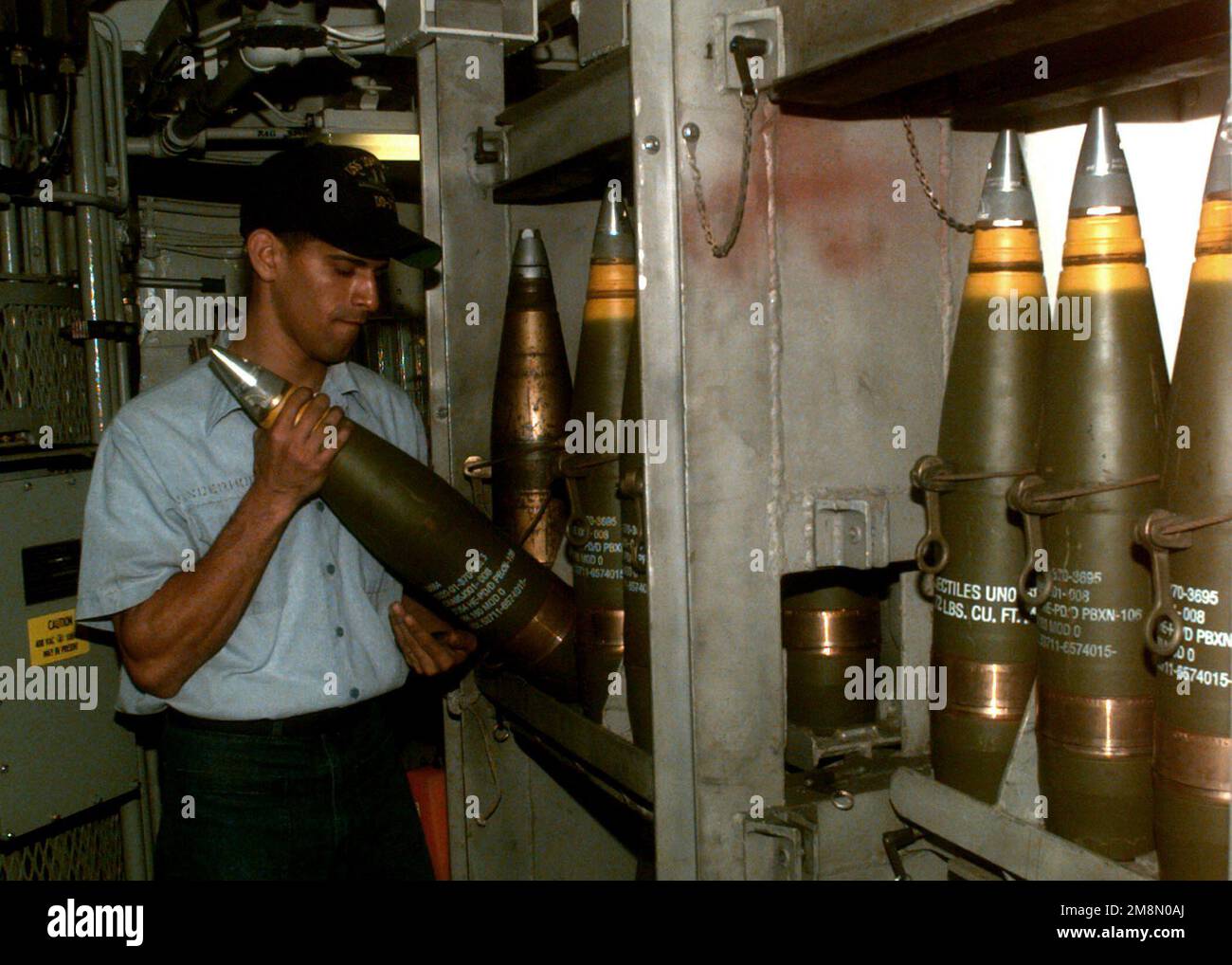 Gunners Mate 3rd Class Walter Vanderhorst stores projectiles for the 5 ...