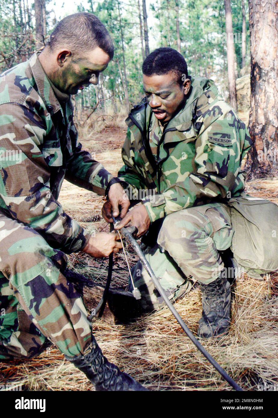 SFC James Henderson (right), wearing Gortex field jacket, assists SPC ...