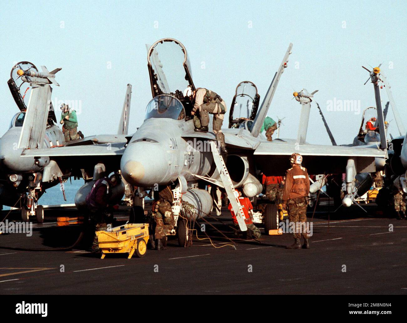 A pilot climbs into an F/A-18C Hornet attached to Marine Fighter Attack ...