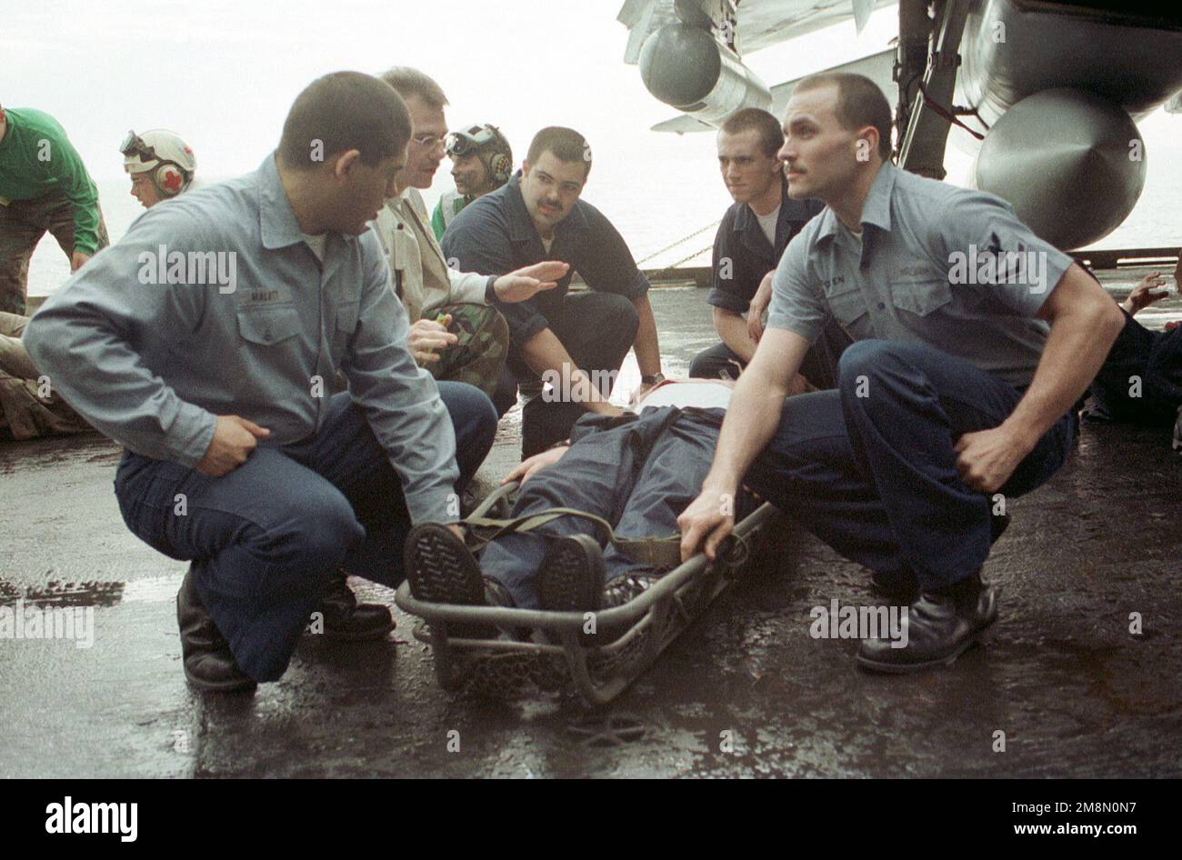 US Navy Crewmen help carry a wounded shipmate during a mass casualty ...