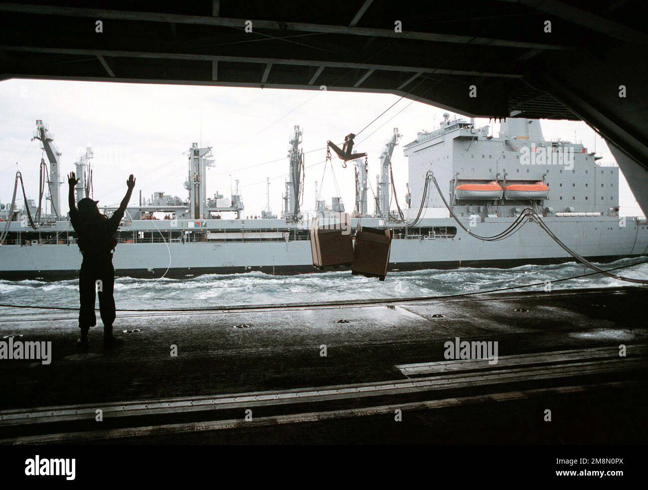 US Navy Boatswains Mate 3rd Class (BM3) Christian Kerlick signals the ...