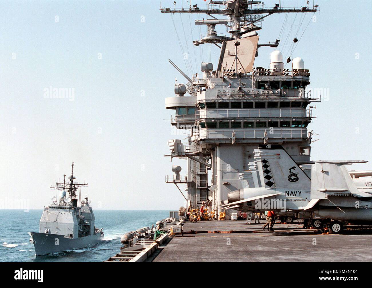 The guided missile cruiser USS NORMANDY (CG 60) steams alongside the ...