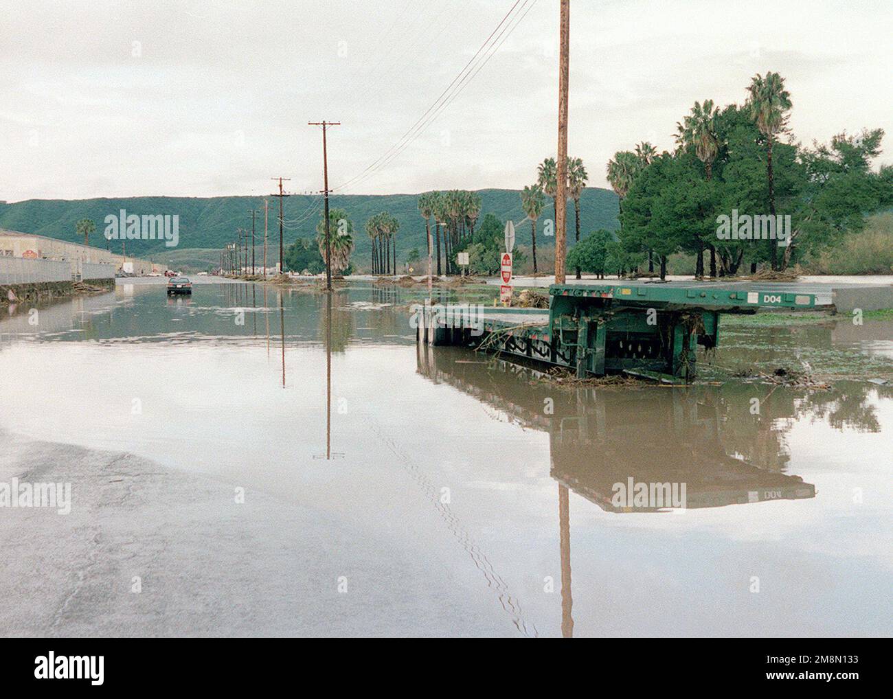 A Drop Deck Flatbed trailer sits on the side of a flooded road at Camp ...