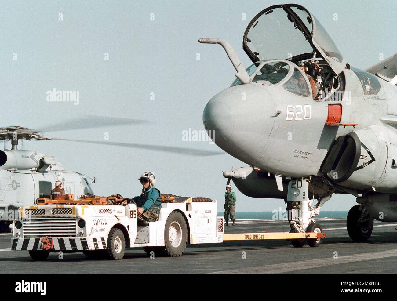 A US Navy flight deck tractor operator repositions an EA-6B Prowler ...